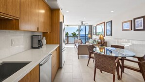 Cozinha moderna com armários de madeira, cafeteira e vista para o exterior.
