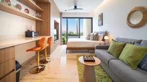 Uma sala de estar moderna com sofá, mesa de centro, cama e cozinha com balcão e cadeiras.