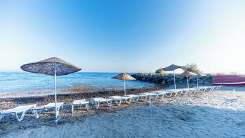 Perto da praia, espreguiçadeiras, guarda-sóis de praia