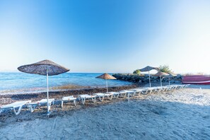 Perto da praia, espreguiçadeiras, guarda-sóis de praia 