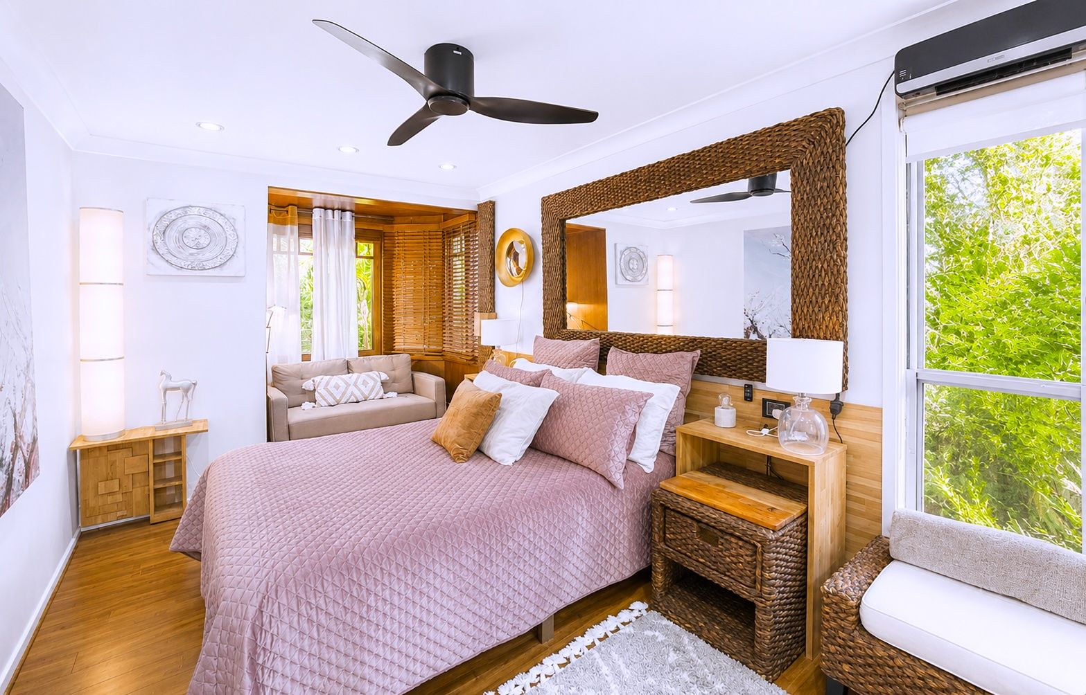 Quarto com cama, mesa de cabeceira, abajur e ventilador de teto.