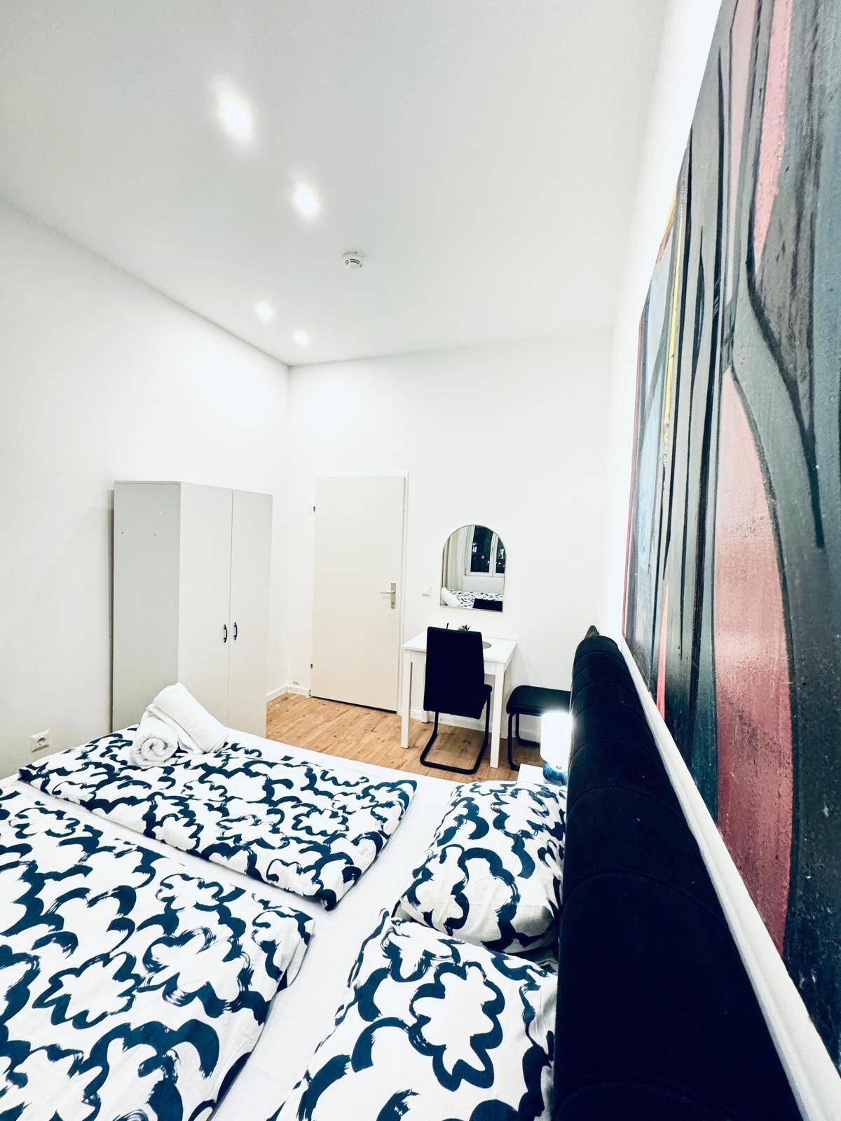 Quarto moderno com cama, escrivaninha e guarda-roupa.