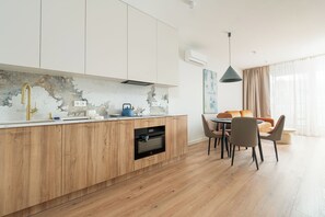 Uma cozinha moderna com armários de madeira, forno embutido e backsplash de mármore.