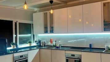 Um frigorífico, um micro-ondas, utensílios de cozinha