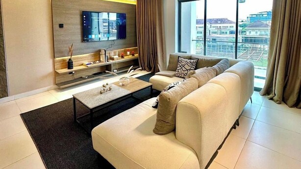 Uma sala de estar moderna com sofá, mesa de centro e televisão.