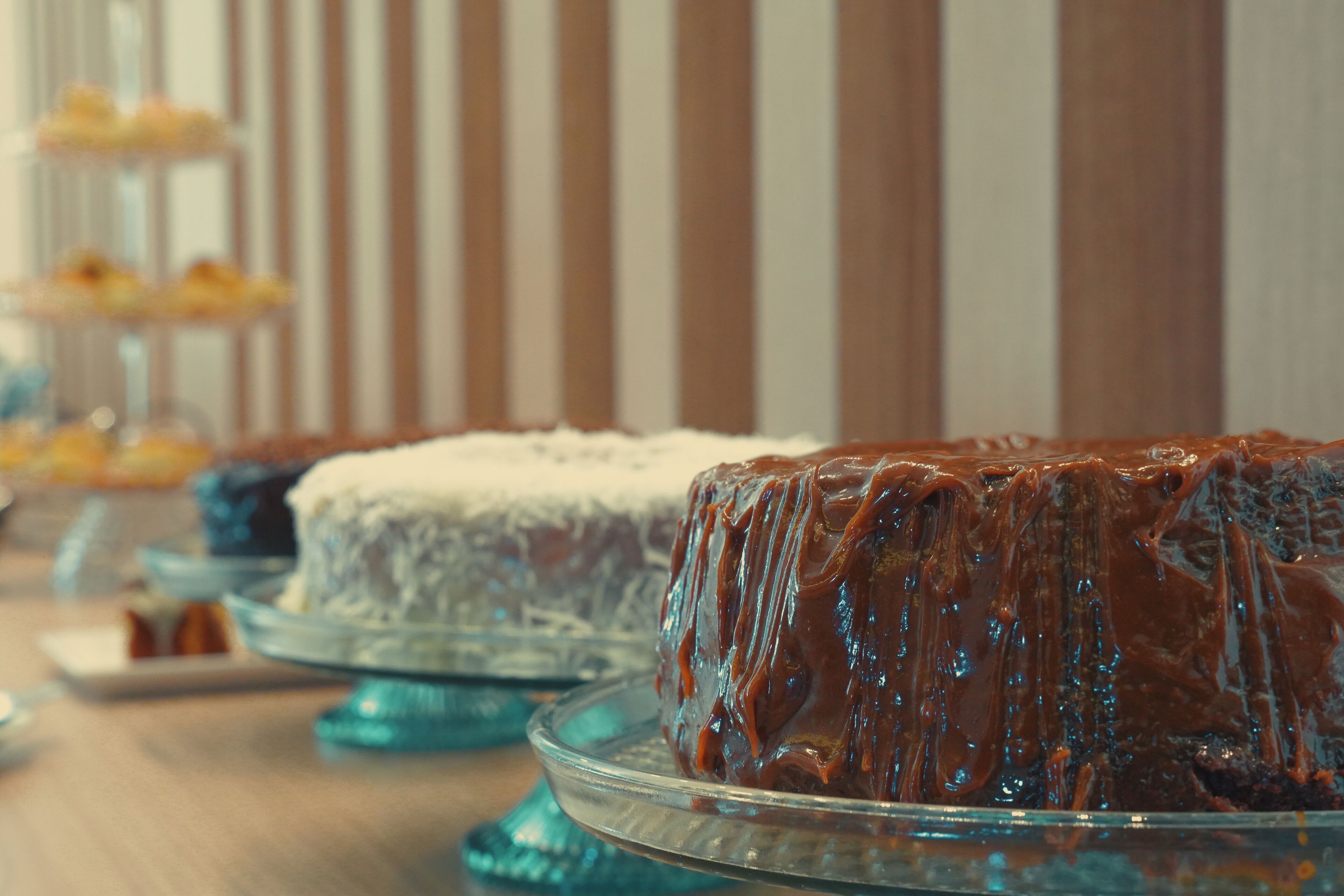 Uma mesa de sobremesas com diversos bolos e doces.