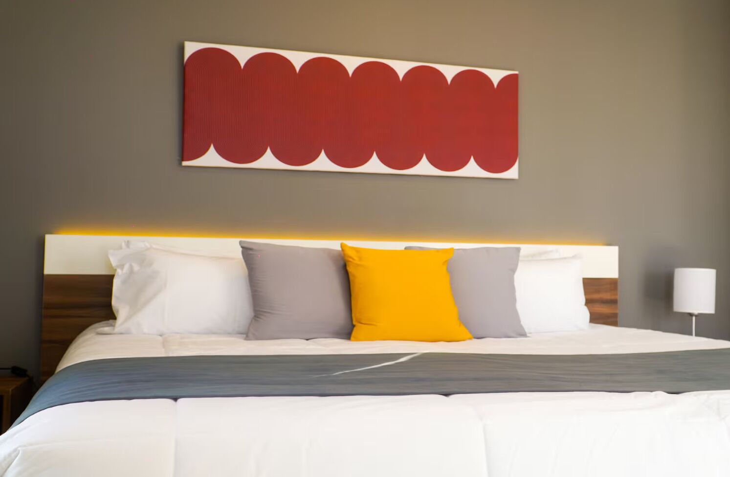 Uma cama com cabeceira, travesseiros e cobertor.