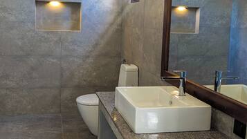 Banheira e chuveiro separados, secador de cabelo, chinelos