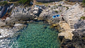 Sítio histórico com antigas estruturas de pedra e uma piscina de águas claras.