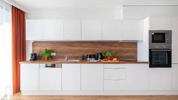 Uma máquina de café expresso, uma cafeteira/bule, uma chaleira elétrica