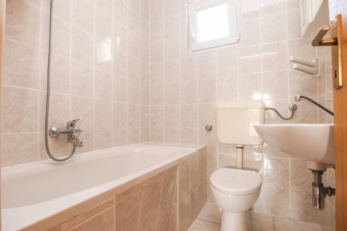 Um banheiro com banheira, vaso sanitário e pia.