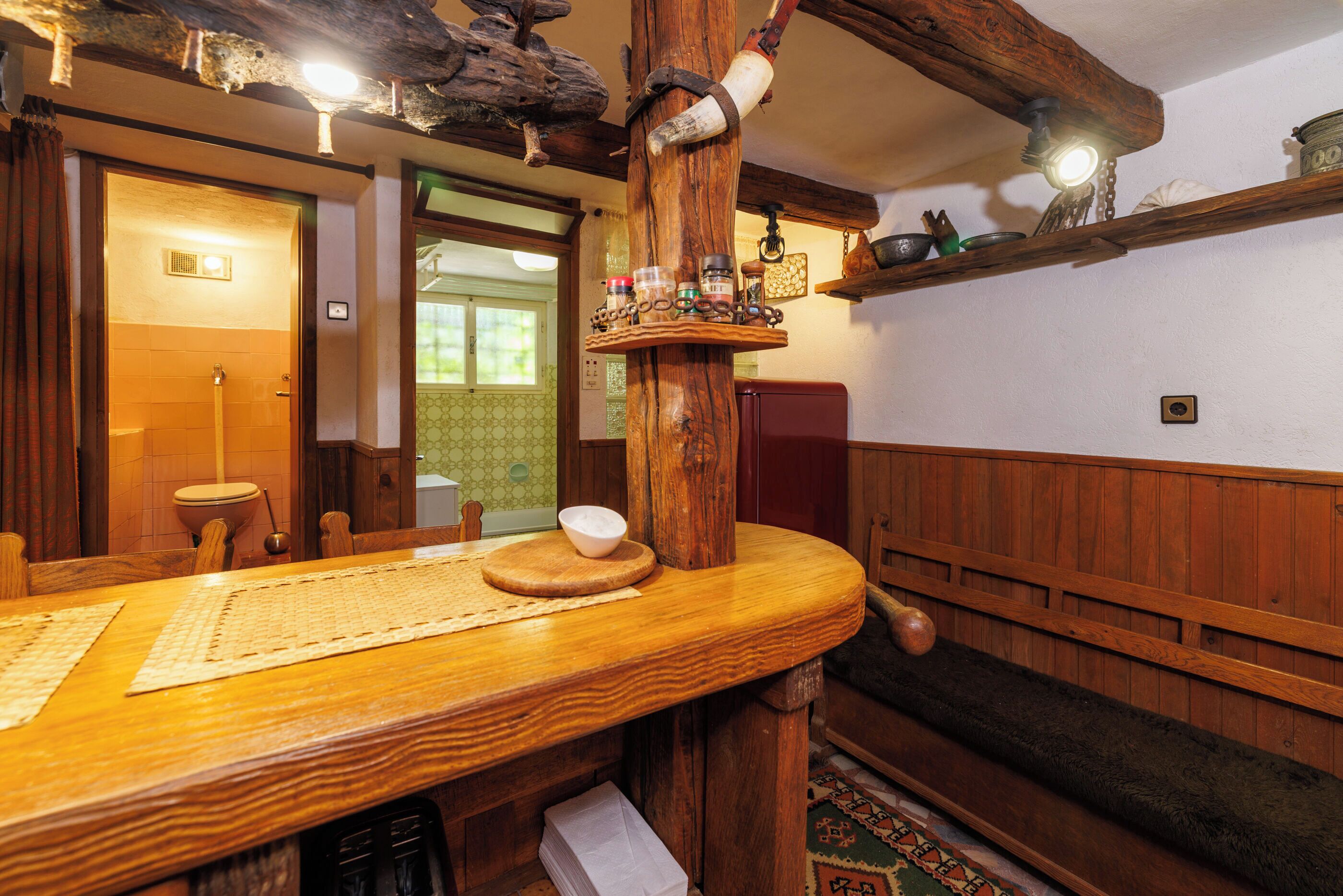 Um interior em madeira com uma mesa de jantar, cadeiras e um banco de madeira.