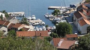 Uma marina com barcos atracados, cercada por edifícios residenciais com telhados de terracota.