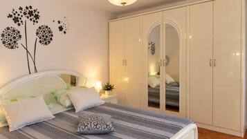 Quarto com cama, mesas de cabeceira, guarda-roupa e decorações nas paredes.