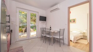 Um espaço compacto com área de refeições, cozinha compacta e quarto.