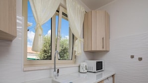 Casa de banho moderna com lavatório, micro-ondas e máquina de lavar roupa.