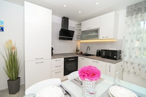 Apartamento (A1) | Cozinha privada | Um frigorífico, um micro-ondas, um forno, uma placa de cozinha 