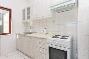 Apartamento (A1) | Cozinha privada | Um frigorífico, um micro-ondas, um forno, uma placa de cozinha 