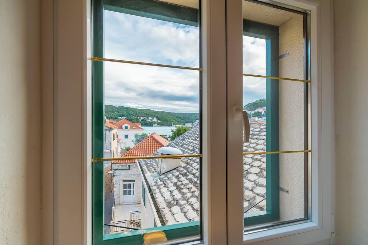 Uma janela com vista para edifícios e um rio.