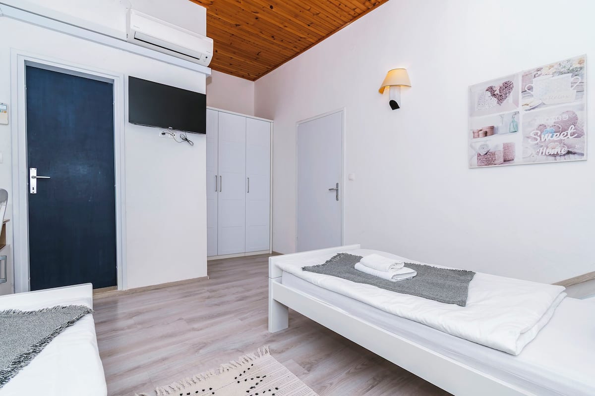 Quarto com cama, guarda-roupa, escrivaninha e luminária na parede.