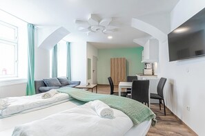 Quarto de hotel moderno com uma cama grande, uma escrivaninha e uma TV.