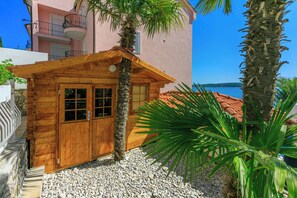 Uma cabana de madeira com base de pedra, porta de madeira e janelas.