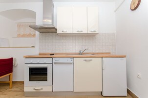 Apartamento (A1) | Cozinha privada | Um frigorífico, um micro-ondas, um forno, uma placa de cozinha