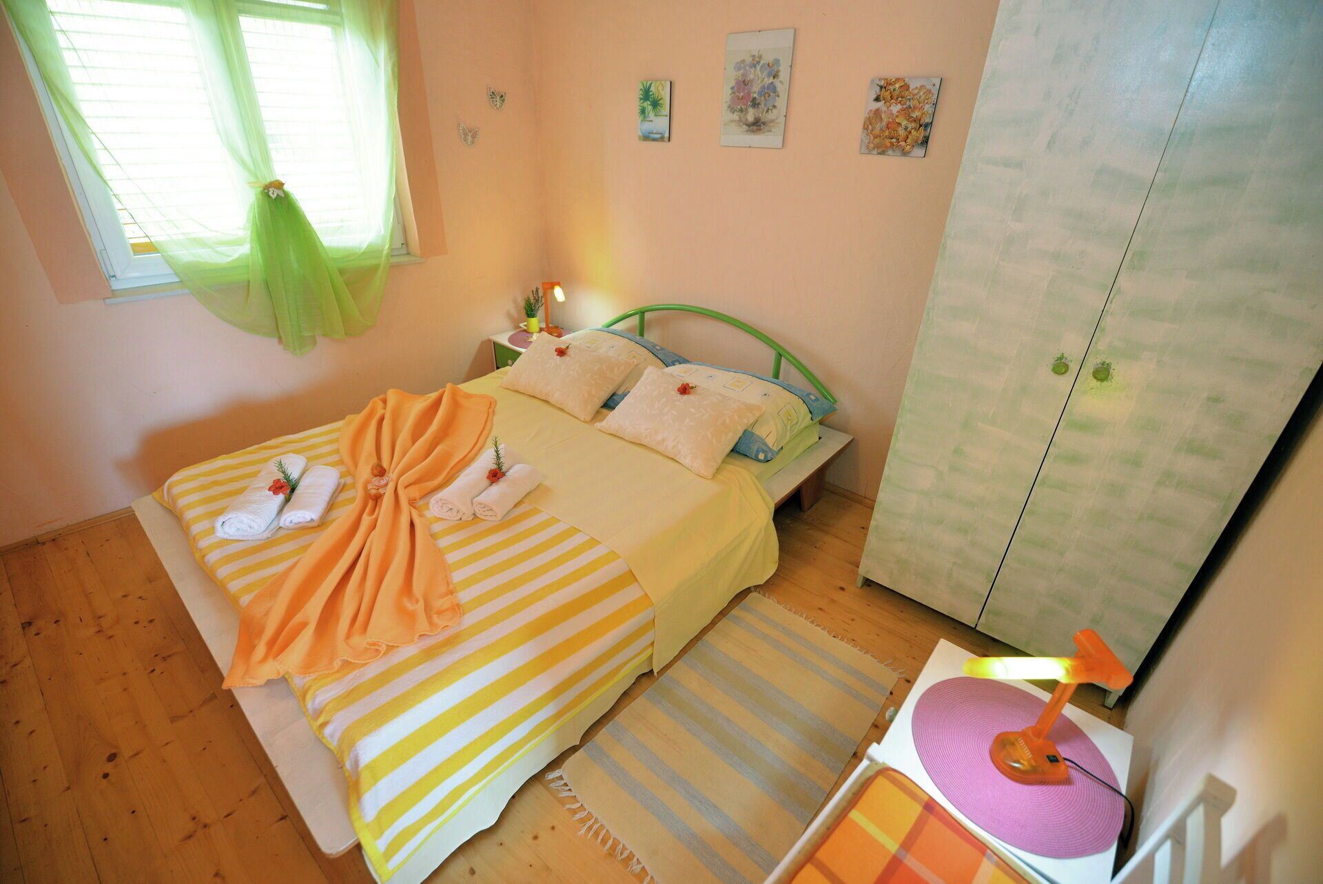 Quarto com duas camas, um guarda-roupa e uma mesa de cabeceira com abajur.