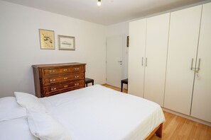 Quarto com cama, cômoda e guarda-roupa.