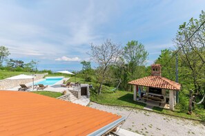 Uma villa com piscina, área de estar exterior e churrasqueira.