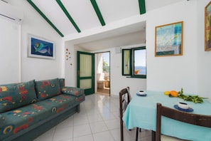 Um quarto com um sofá, uma mesa com uma xícara e limões, e um quadro na parede.