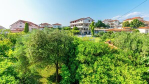 Um bairro residencial com várias casas de dois andares, um espaço aberto central e muita vegetação.