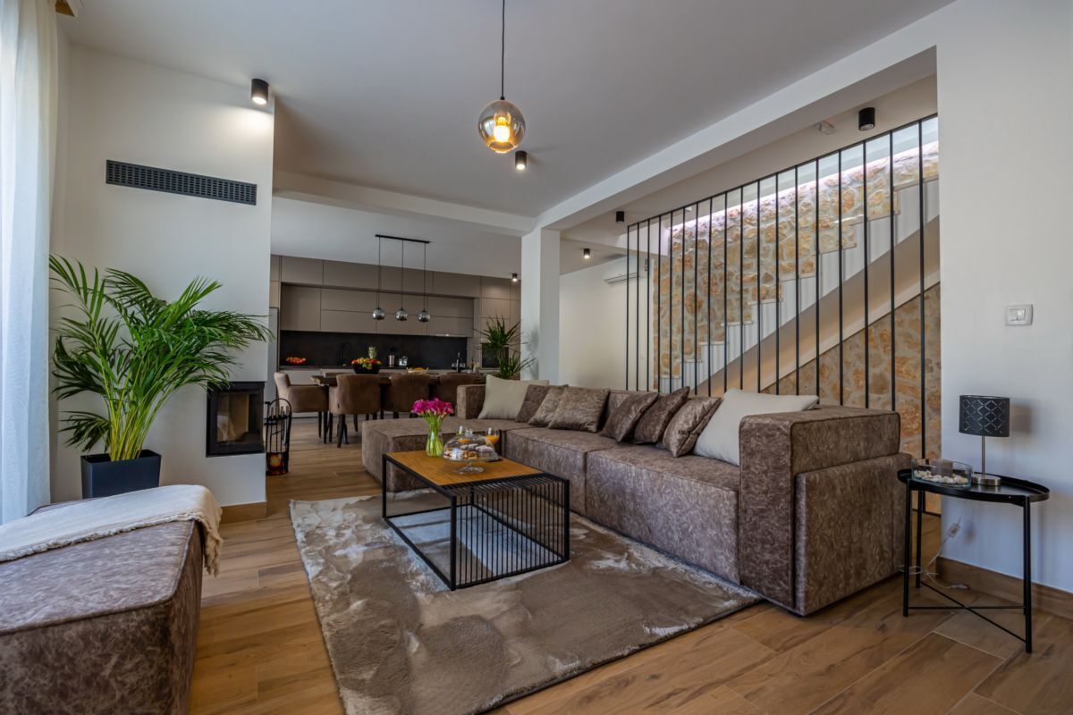 Uma sala de estar moderna com sofá, mesa de centro e escada com guarda-corpo de pedra.