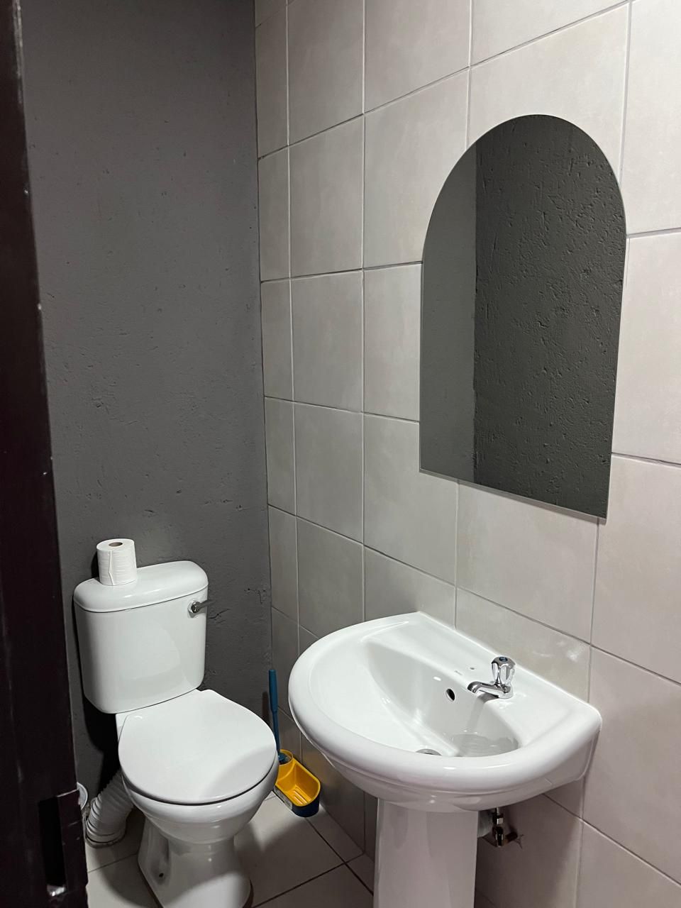 Um banheiro com vaso sanitário, pia e espelho.