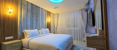 Quarto moderno com cama grande, mesa de cabeceira, espelho e luminária no teto.