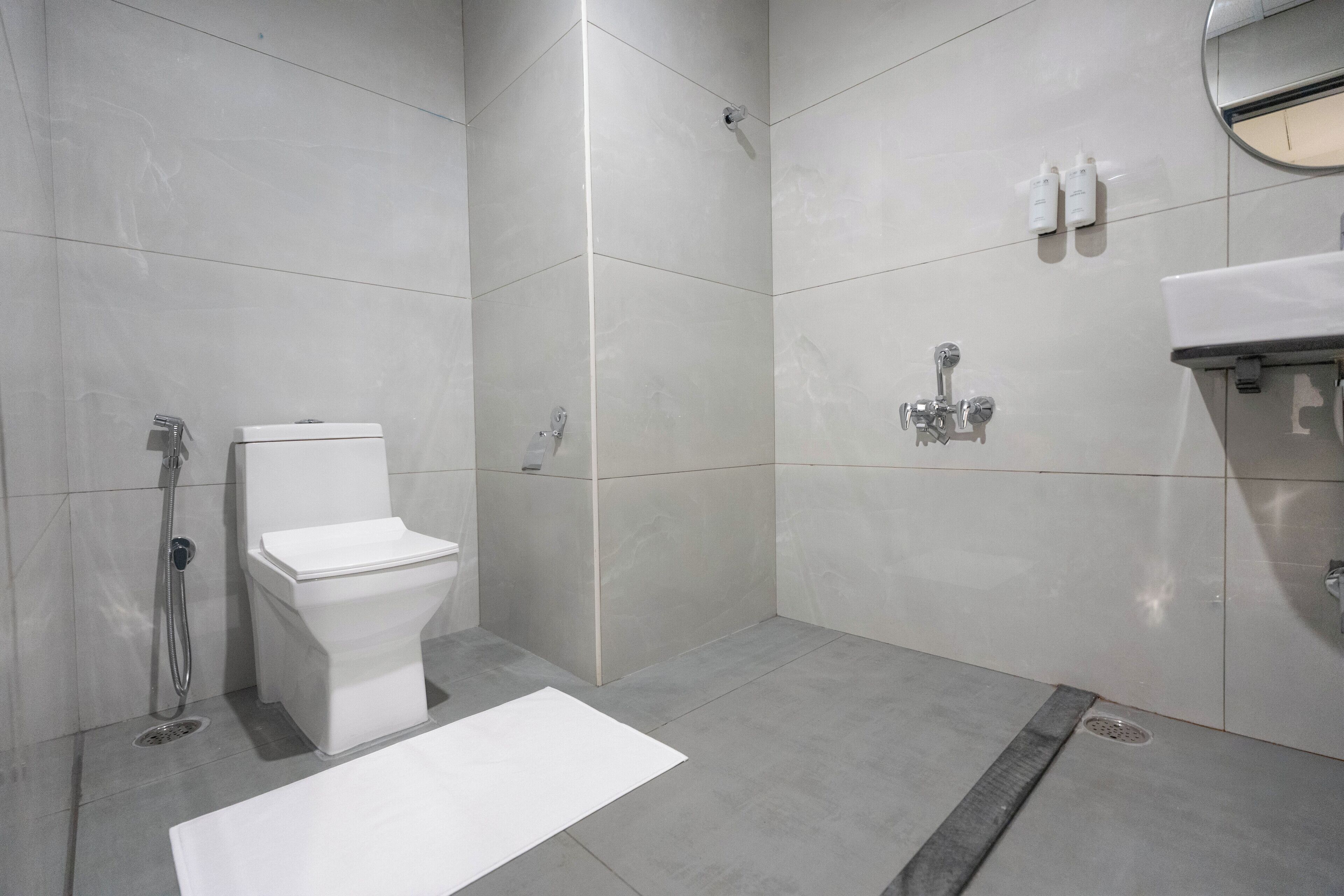 Casa de banho moderna com sanita, chuveiro e lavatório.