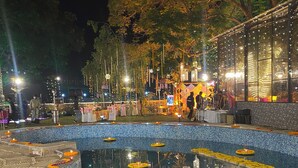 Piscina com arranjos florais decorativos e área de palco para eventos.