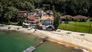Um imóvel costeiro com várias casas, um cais e uma praia.