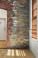 Quarto com parede de pedra, porta de madeira com placa de número e janela com grades de madeira.