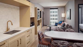 Quarto de hotel moderno com cozinha, sala de jantar e área de estar.