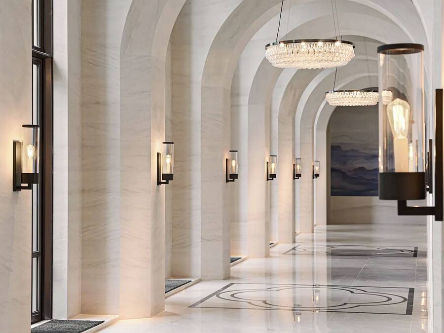 Um hall de hotel moderno com tetos abobadados, lustres e piso de mármore.
