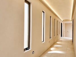 Um corredor com várias janelas e iluminação embutida.