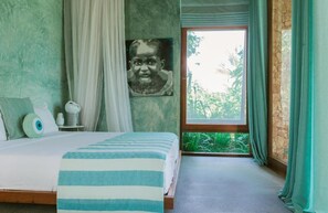 Um quarto com cama, janela com cortinas, quadro na parede e pequena mesa de cabeceira com abajur.