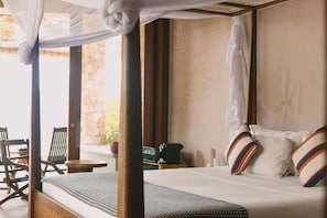Um quarto com uma cama de dossel, uma mesinha e uma cadeira.