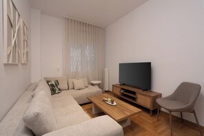 Apartamento Deluxe, cozinha | Sala | Televisor de 50 polegadas com canais por cabo 