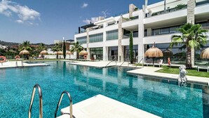 Um hotel moderno com uma piscina grande, área de estar ao ar livre e vista para a paisagem circundante.