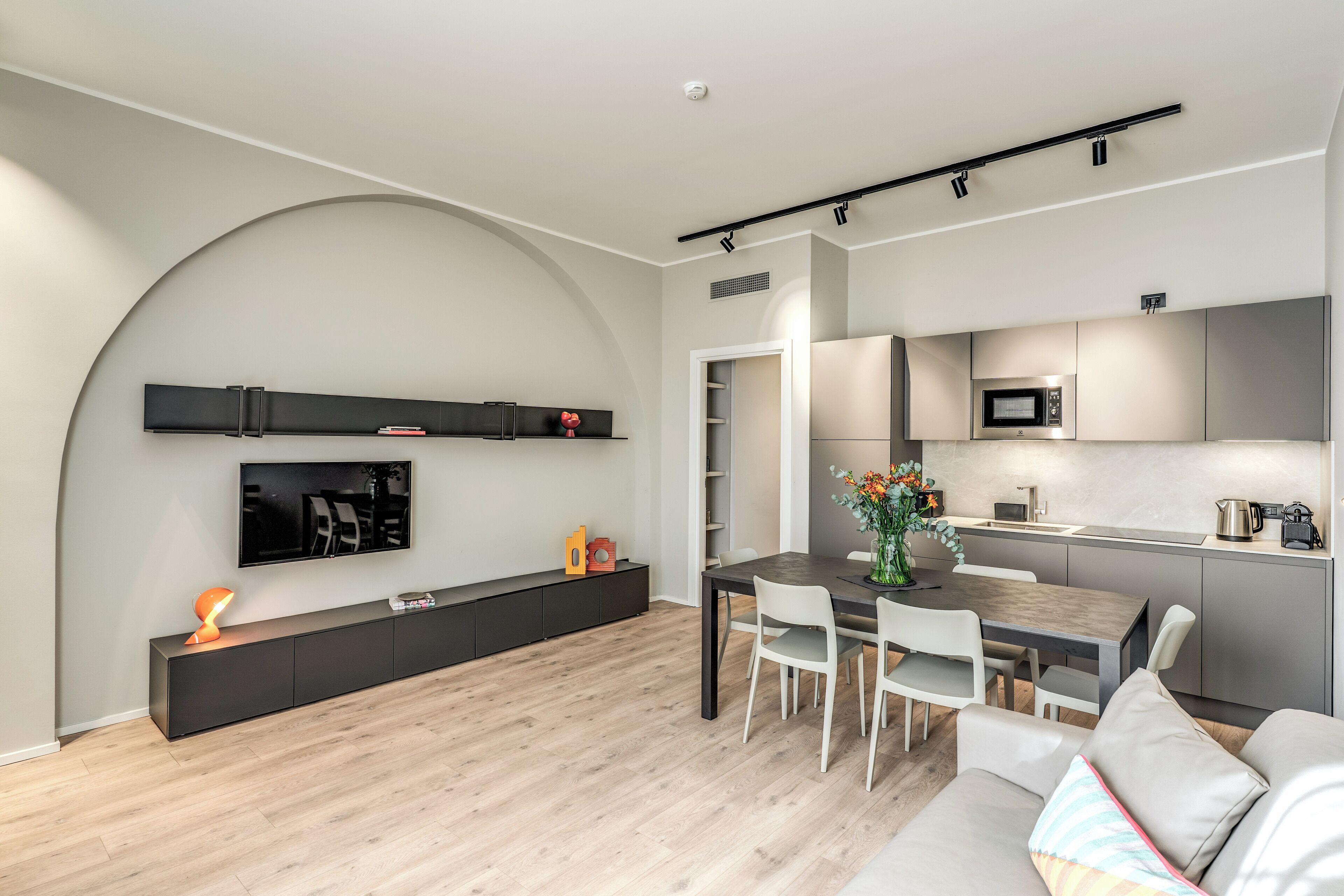Cozinha moderna com micro-ondas, fogão e pia. Possui área de jantar com mesa e cadeiras.