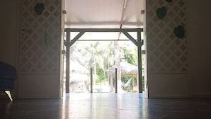 Uma porta aberta que dá para uma área externa com estrutura de telhado de palha.