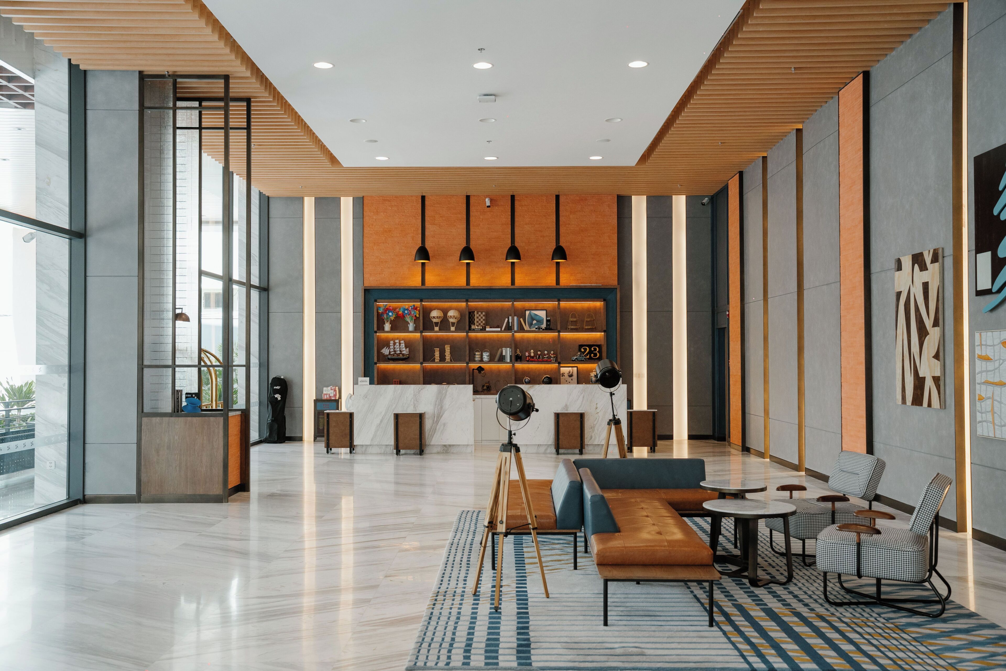 Um lobby moderno com balcão de recepção, área de estar e exposição de objetos.