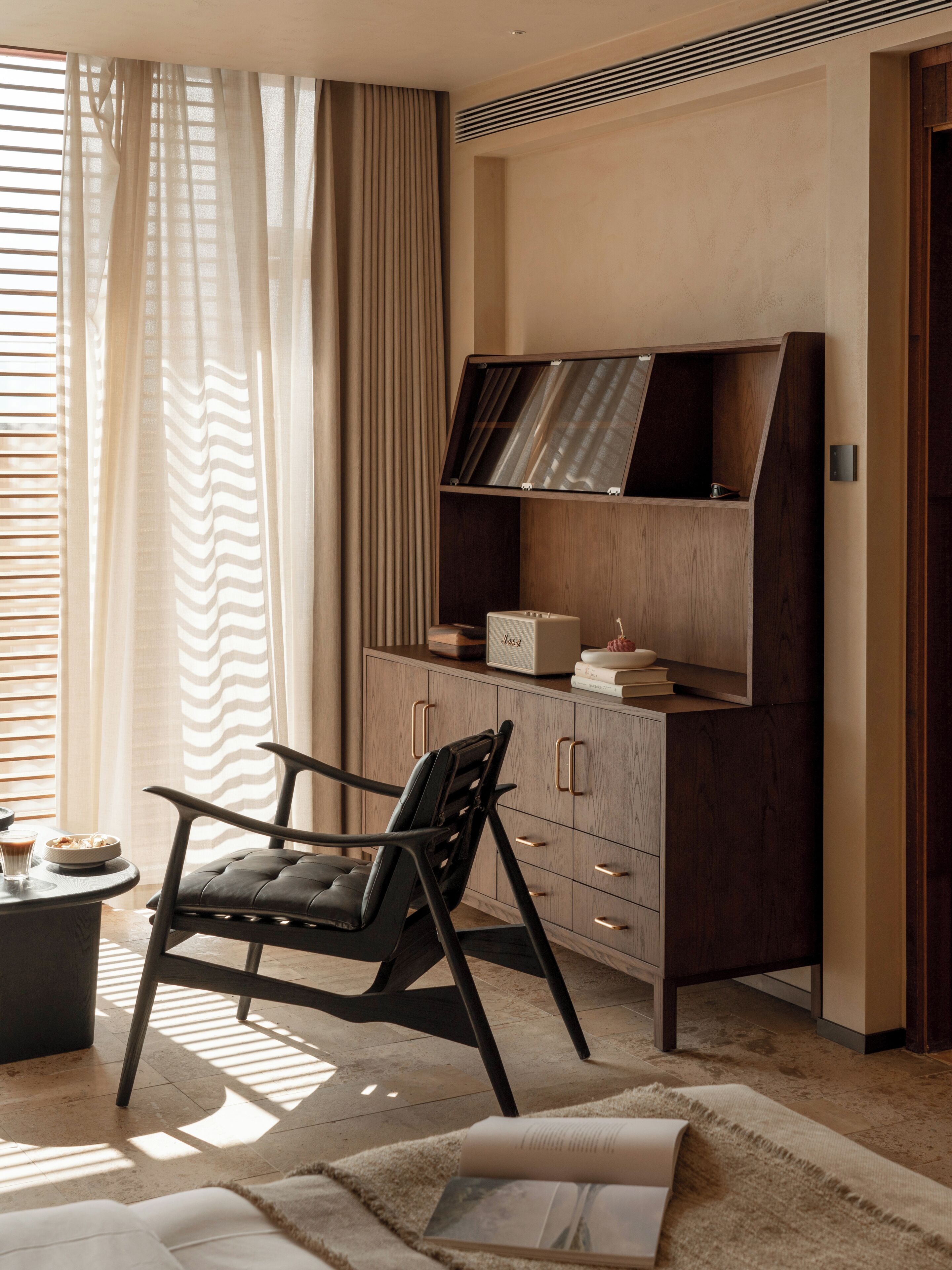 Quarto moderno com escrivaninha, cadeira e estante.